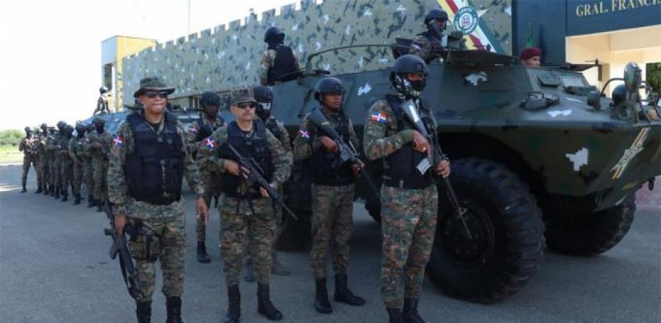 Fuerzas del Ejército dominicano caminan alrededor de una tanqueta ...